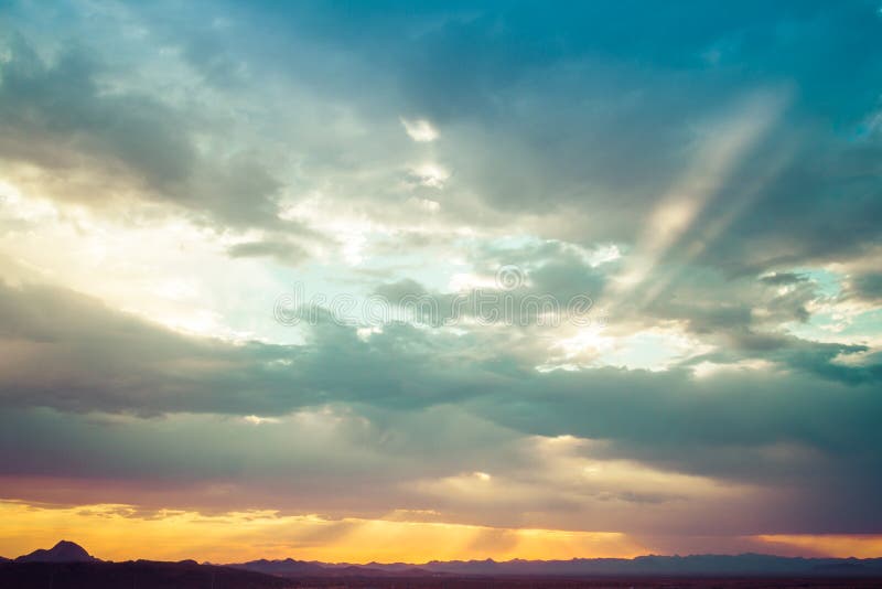 Sunbeams Radiating Out Under Colorful Clouds Stock Photo - Image of ...