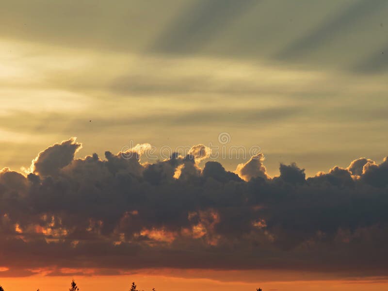 The Sunbeams of the Setting Sun Shine through the Clouds in the Evening ...