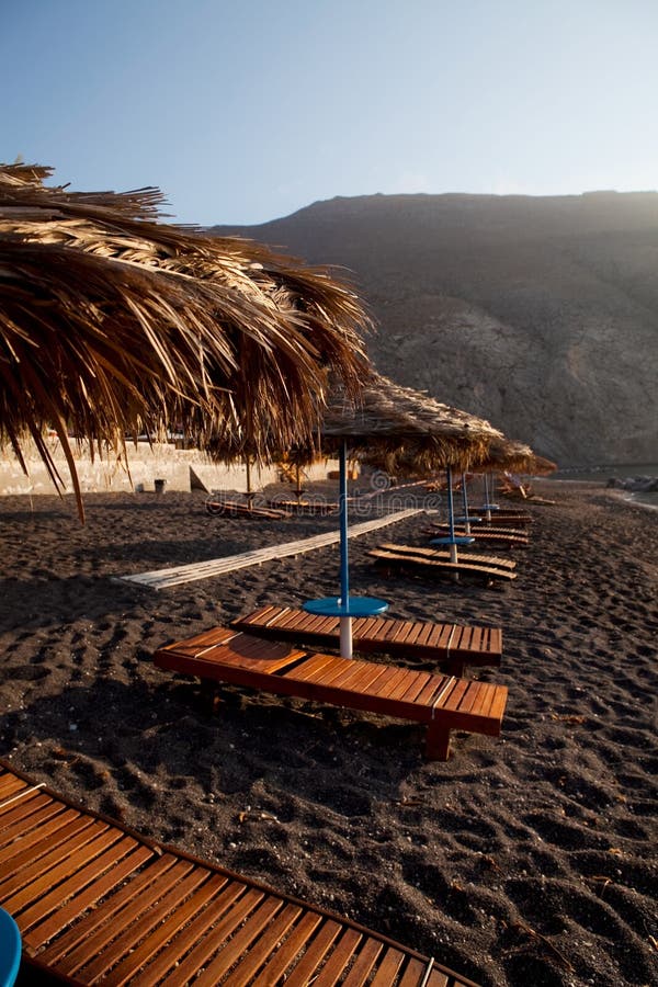 Sunbeds in Perissa, Santorini, Greece Stock Image - Image of dawn ...