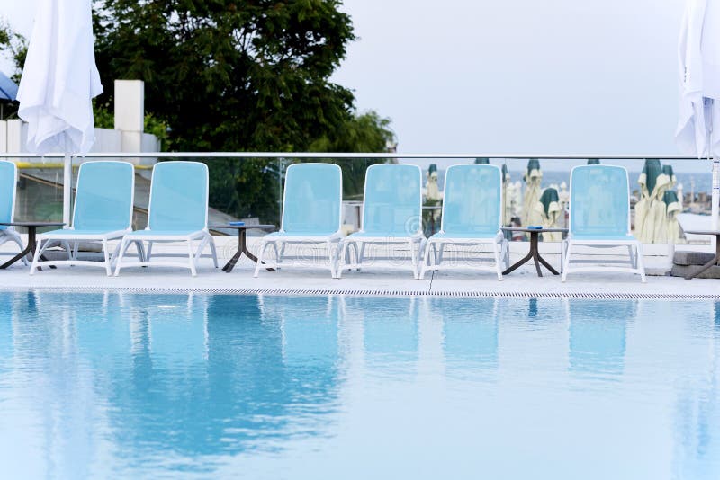 Sunbeds with pool view stock image. Image of sunbeds - 154266913