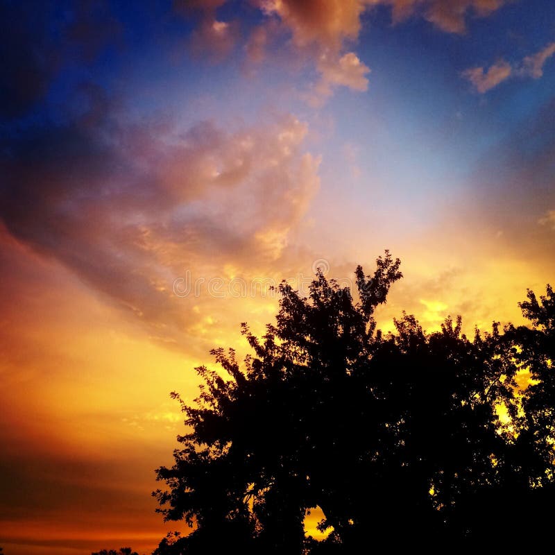 Sun Setting Sunburst Behind Mountain With Blue Sky And Clouds Ti Stock ...