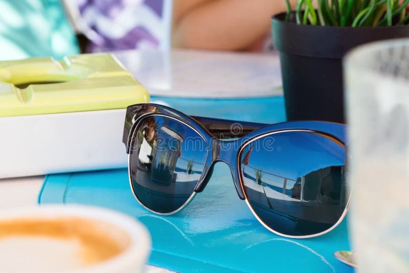Sunglasses on the Table on Reflection Sea and Blue Sky Stock Photo ...
