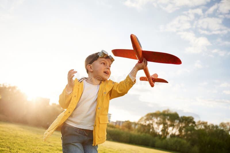 Against Sky with Amazing Sunshine. Little Boy is Playing with Toy Plane ...