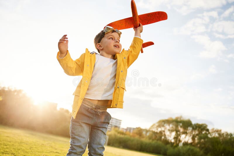 Against Sky with Amazing Sunshine. Little Boy is Playing with Toy Plane ...