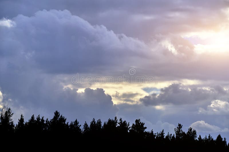 Sunlight Breaking through Gap in Storm Clouds Against Dark Silhouette ...