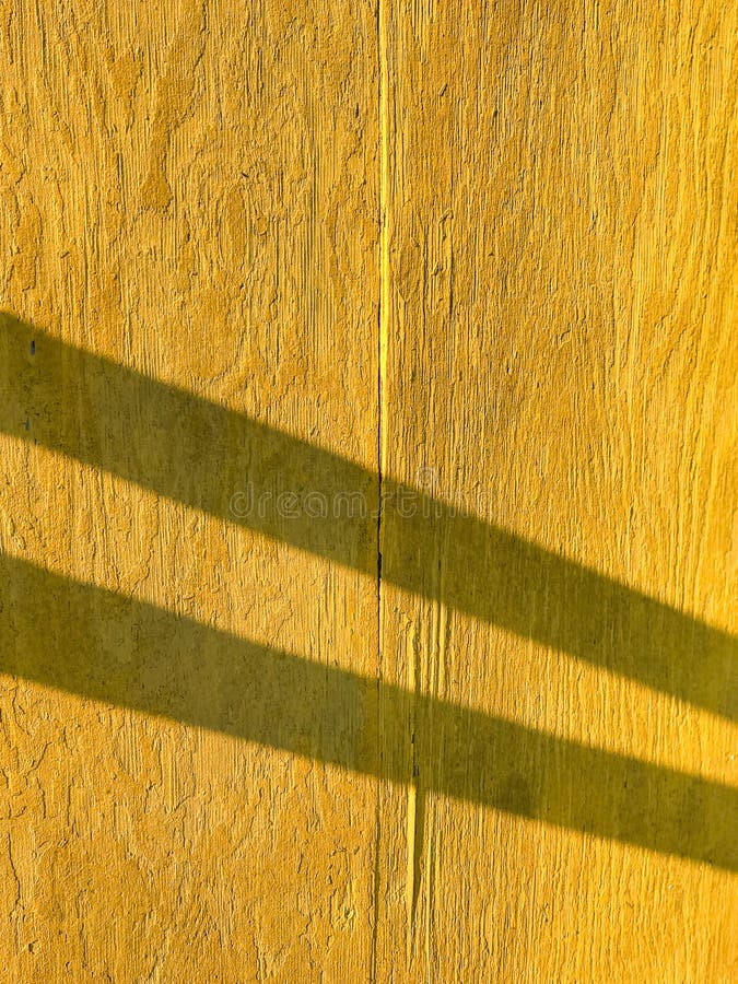 Sunlight Casting Sharp Shadows on a Textured Yellow Wall Stock Image ...