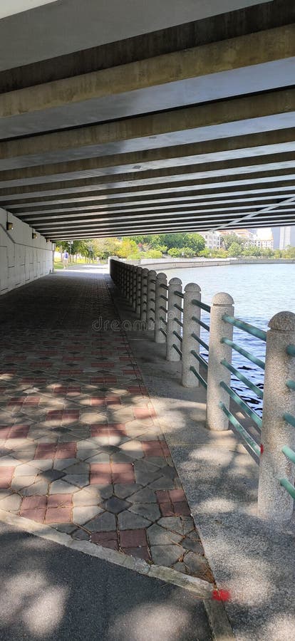 Sunlight Falling on Patterned Walkway Under a Bridge Stock Image ...