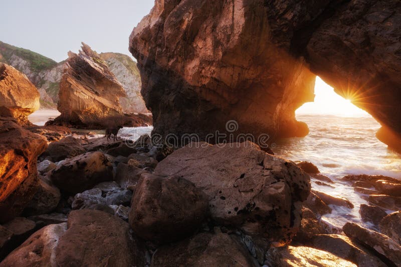 Sunlight through rock arch stock photo. Image of shore - 73550758