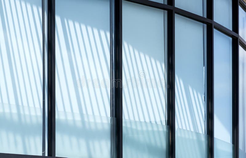 Sunlight and Shadow on Surface of Curve Glass Building Wall with White ...