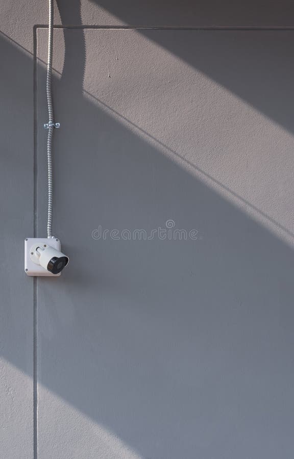 Security Camera with Flexible Metal Conduit on Gray Cement Wall in ...