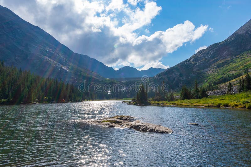 Sunlight Streaming through the Clouds Over a Mountain Lake Stock Image ...