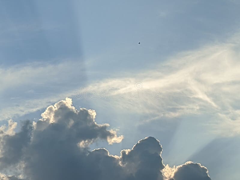Sunlit Clouds, Blue Sky, and Distant Flying Object. Stock Image - Image ...