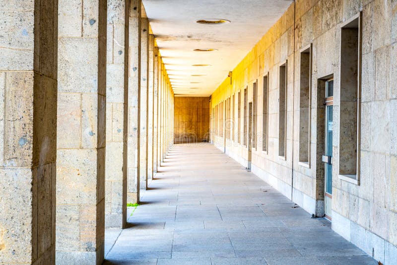 Sunlit Corridor with Columns and Doors Stock Image - Image of building ...