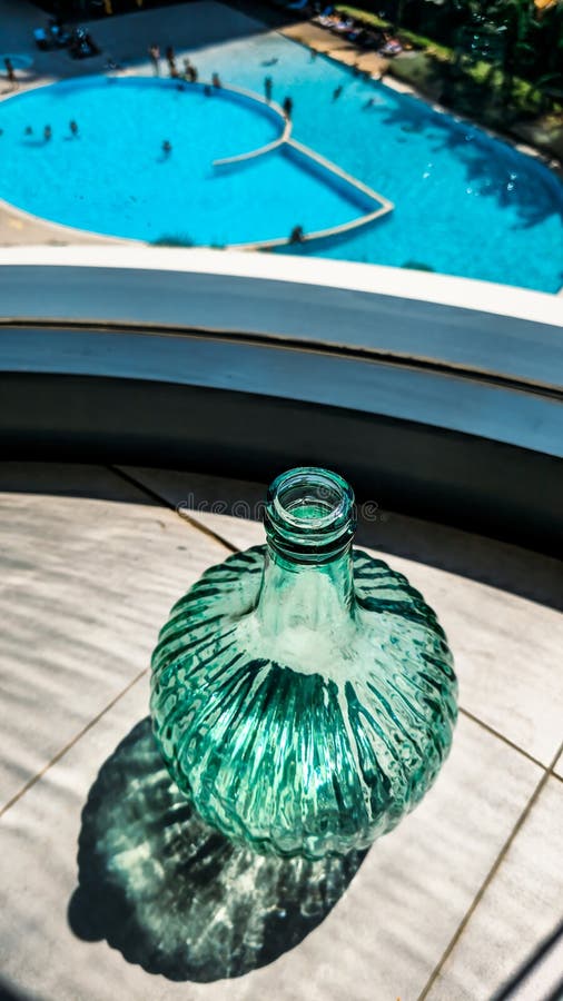 Sunlit Glass Bottle with Pool and Modern Architecture Stock Image ...