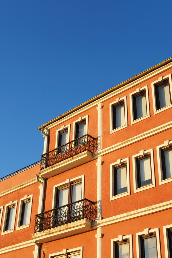 Sunlit Orange Building with Balconies Stock Photo - Image of design ...