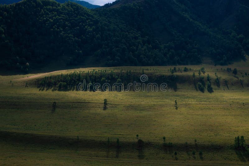 Sunlit Valley with Mountain Shadows and Trees Stock Photo - Image of ...