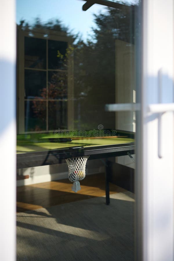 Sunlit View of a Pool Table and Pool Table Pocket through a Patio Door ...