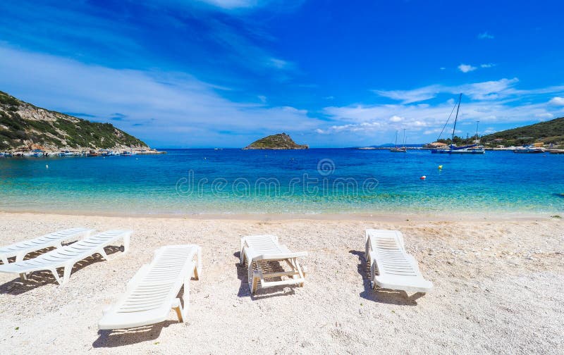 Sunny Summer Beach in Greece with Sun Beds and Small Boat Stock Image ...