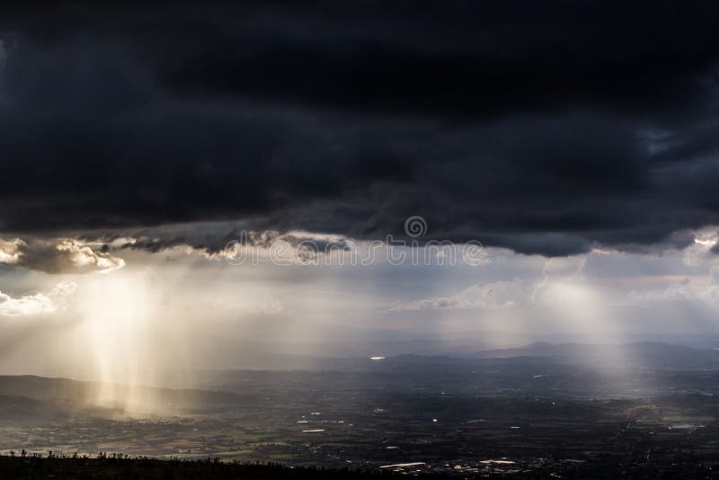 Sunray Shines through Clouds and Rain Over the Mountains in the Middle ...