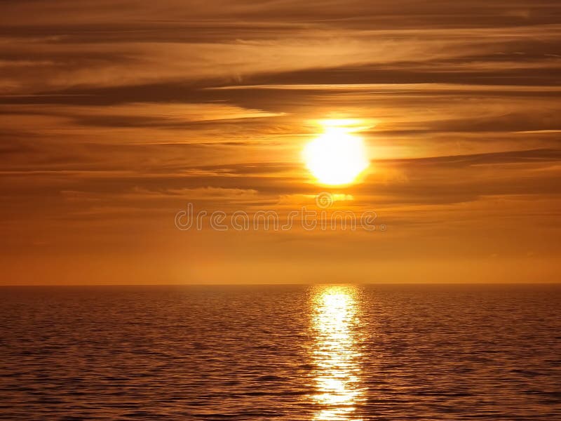 Sunrise Over the Calm Ocean Throwing Shades of an Intense Orange Stock ...