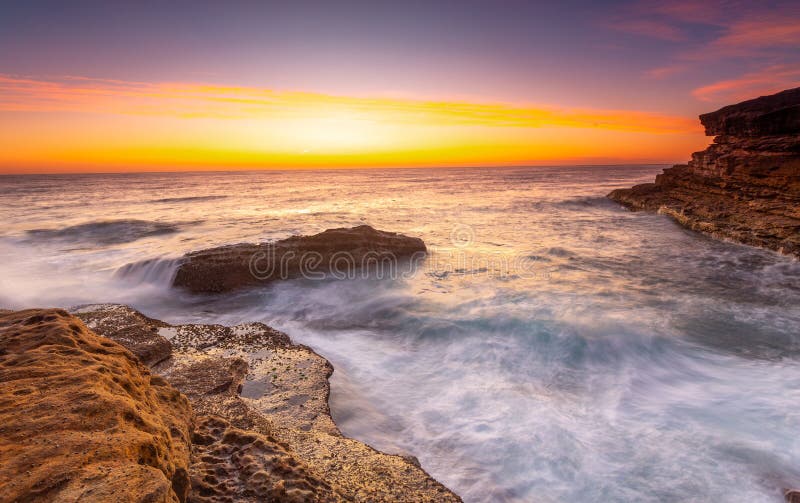 Sunrise Over the Ccean with Some Foreground Rocks of Eroded Sandstone ...
