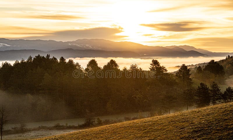 Sunrise Over a Mountain Below a Misty Valley Stock Image - Image of ...