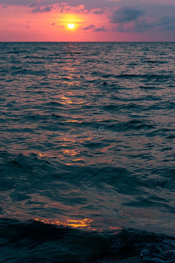 The Sun Rising Over the Water in the Sky Over the Ocean Stock Image ...