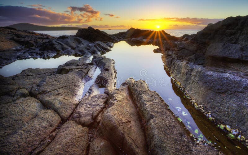Sunrise over rocks stock photo. Image of beach, rocks - 36148430