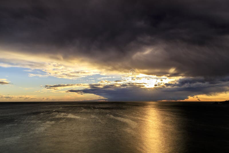 Sunrise Over the Sea with Sun Rays Passing through Dark Storm Clouds ...