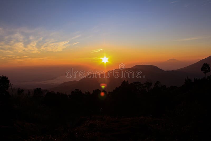 Sunrise Peeking from Above the Clouds on the Mountains Stock Image ...