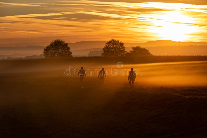 Sunrise with Three People in the Mist Stock Photo - Image of ...