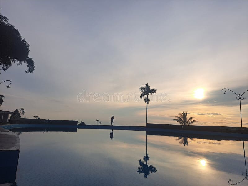 The Sunrise is Visible at the Edge of the Swimming Pool Stock Photo ...