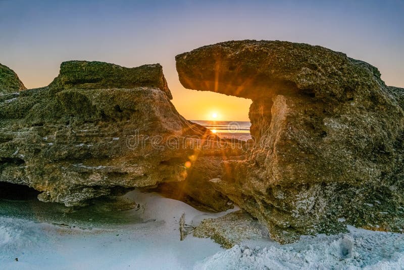 Sunrising through the Rocks Stock Image - Image of sunrising, beach ...