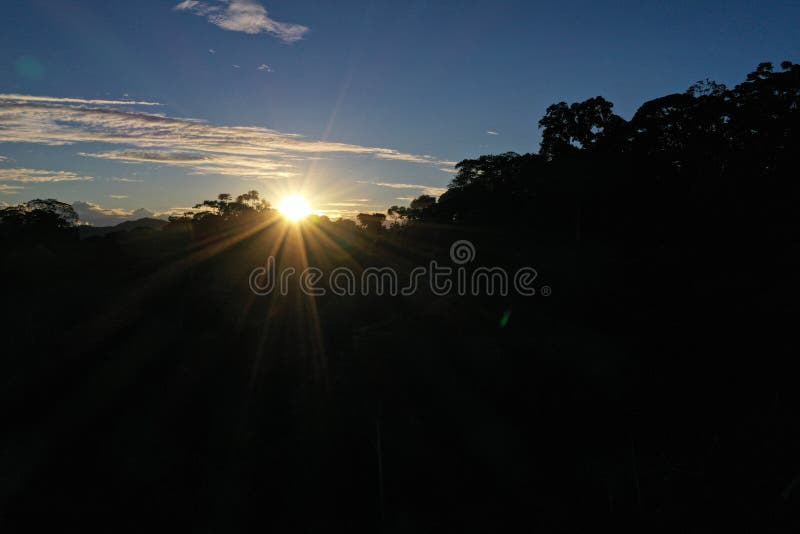 Sunset Above a Tropical Rainforest with Sunbeams Over the Canopy Stock ...