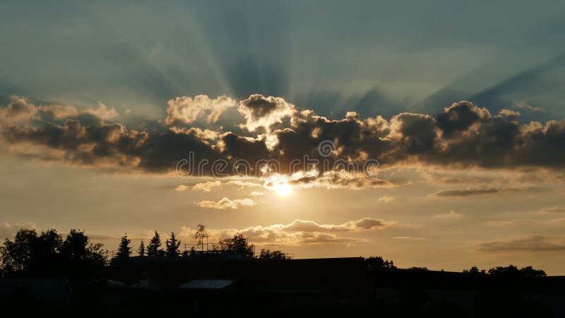 Sunset with Back-lit Clouds and Light Rays in the Sky, Over Trees and ...