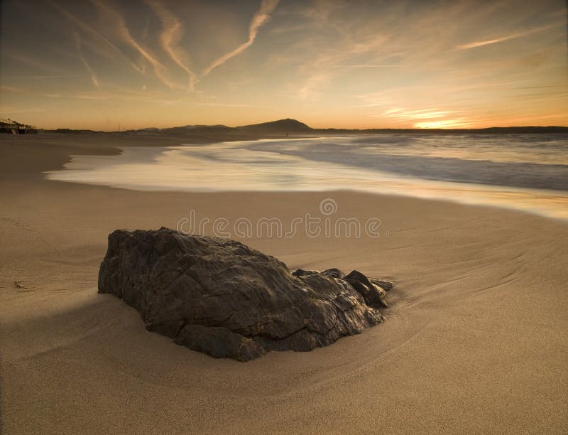 Sunset on the Beach with Rock in the Foreground Stock Photo - Image of ...