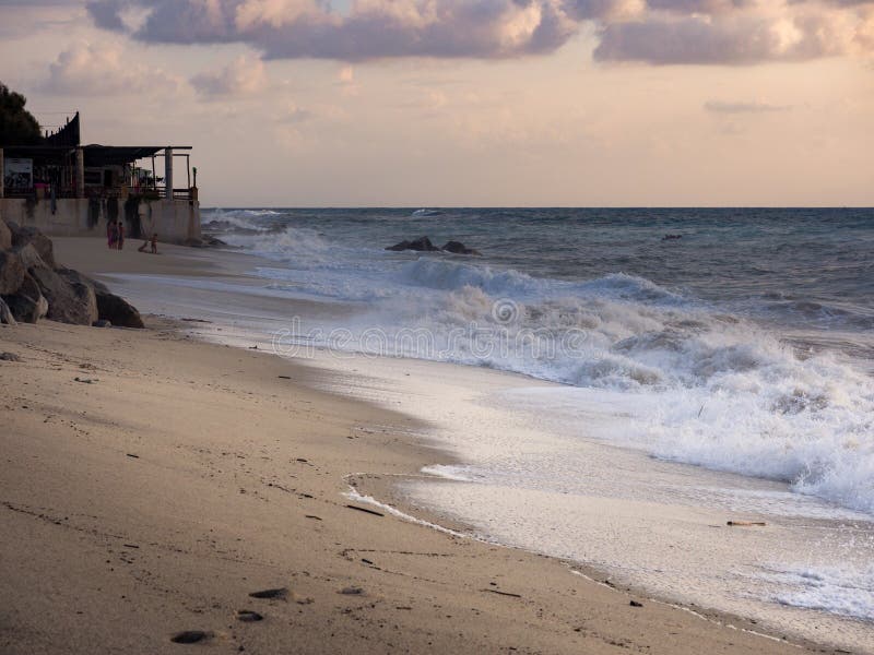 Beach at Sunset with Rough Sea and Crashing Waves Stock Photo - Image ...