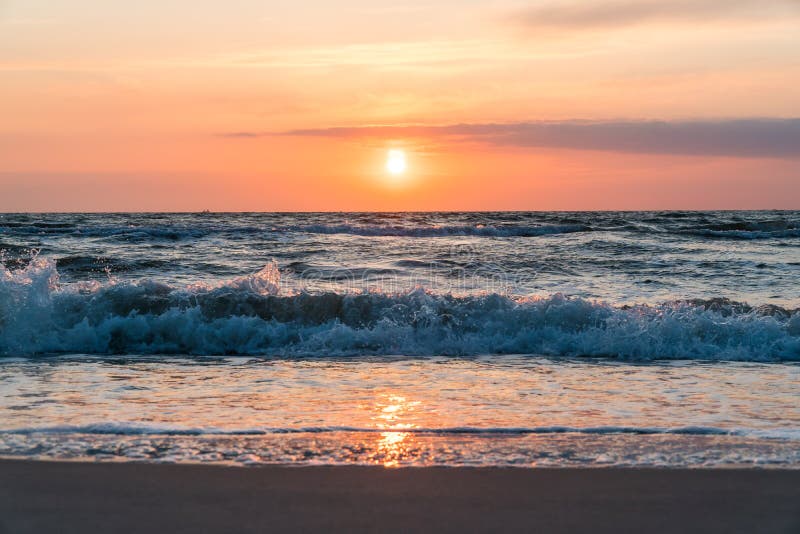 Sunset at the Beach with Sand and Waves in the Forground and Reflection ...