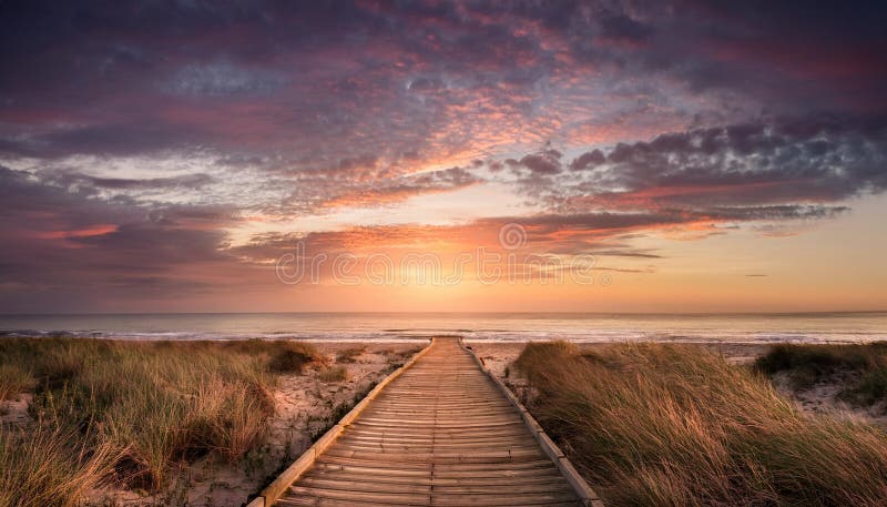 Sunset at a Beach with a Wooden Pathway and Vibrant Sky Stock ...