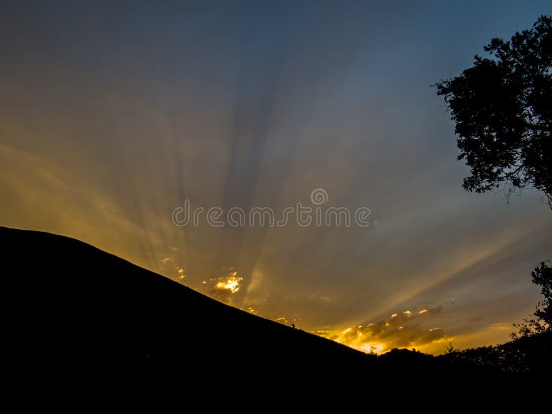 Sunset With Rays Behind Hill Stock Photo - Image of sunny, colors: 37249652