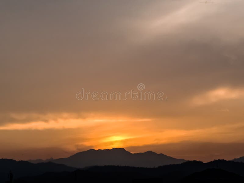 The Sunset Behind the Mountain, the Sky and the Beautiful Clouds Shine ...
