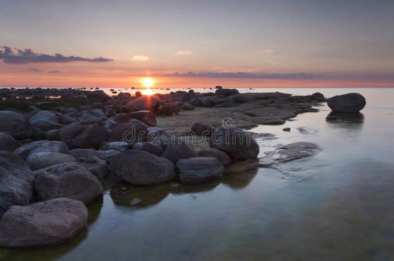 Sunset behind rocky coast stock image. Image of dusk - 32170445