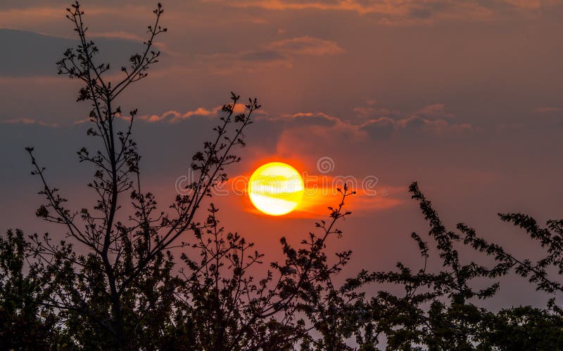 Sunset with Bright Round Sun Disk Behind Dark Clouds Stock Image ...