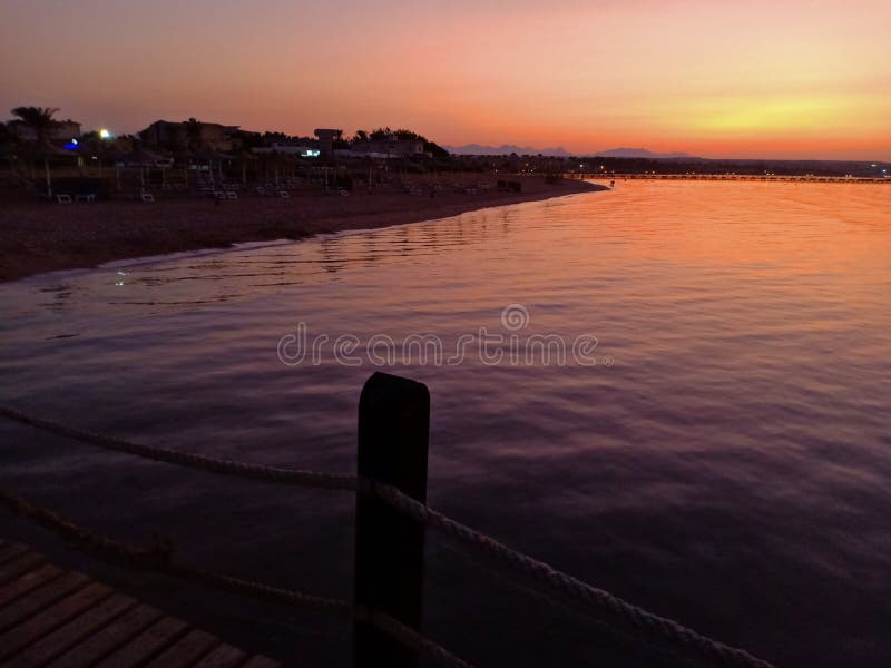 Sunset on calm water stock image. Image of beach, evening - 203089241