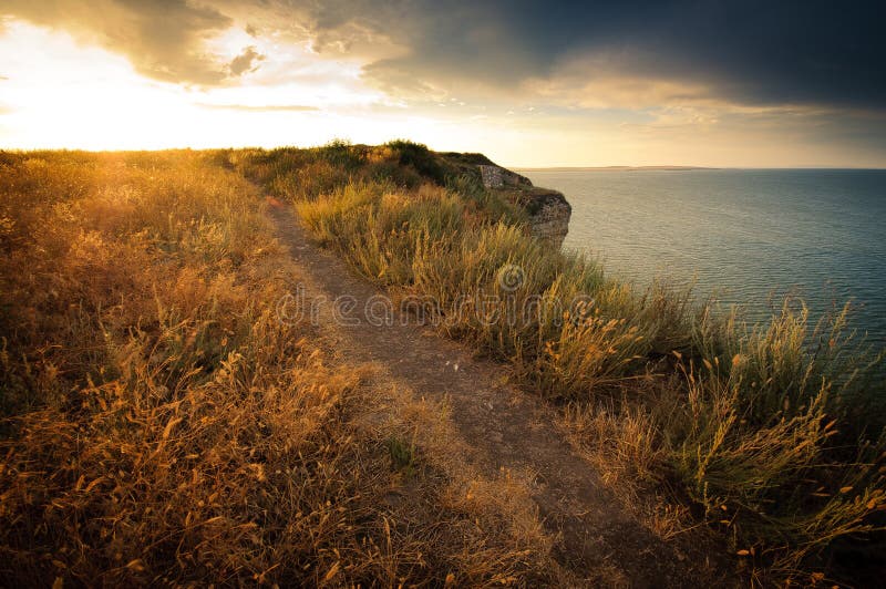 Sunset on the Cliff Near a Lake Stock Photo - Image of yellow, sunset ...