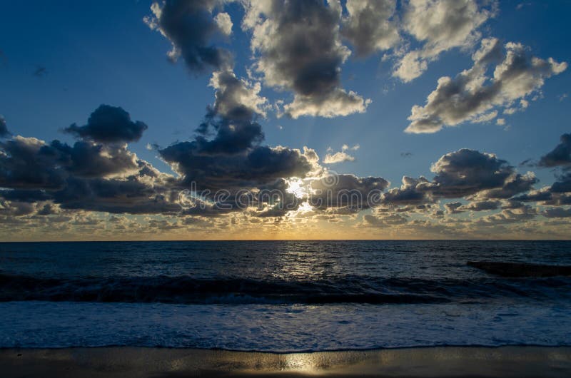 Sunset Clouds Hiding the Sun Over the Sea, with Shadows Stock Image ...