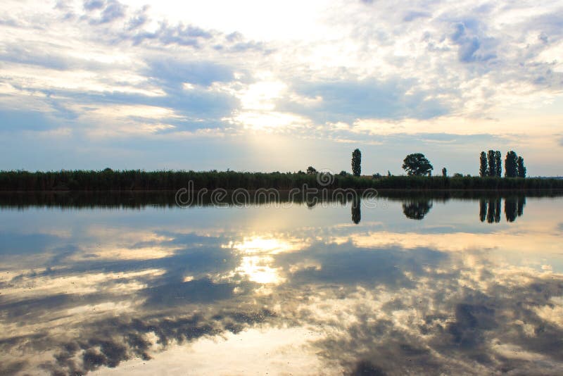 Sunset with Clouds, Light Rays Over River with Reflections Stock Image ...