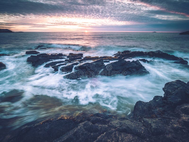 Sunset at Coast with Rocks and Sea in Foreground Stock Photo - Image of ...