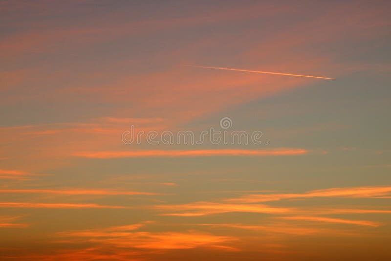 Sunset Colored Clouds in Blue Sky with Contrail Stock Image - Image of ...