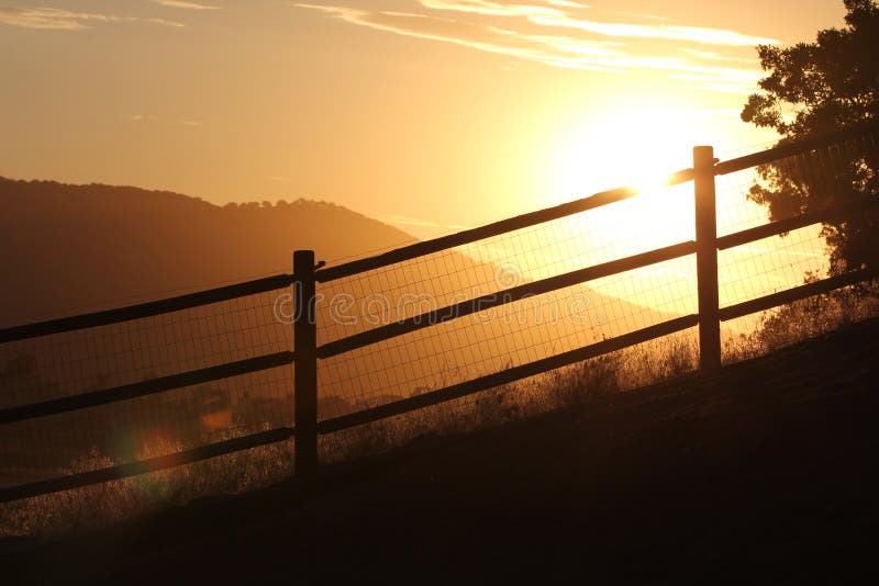 Sunset through a fence. stock photo. Image of country - 38258098